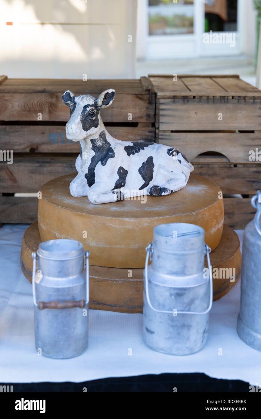 Calf figurine on cheese wheels and milk jugs representing dairy and ...