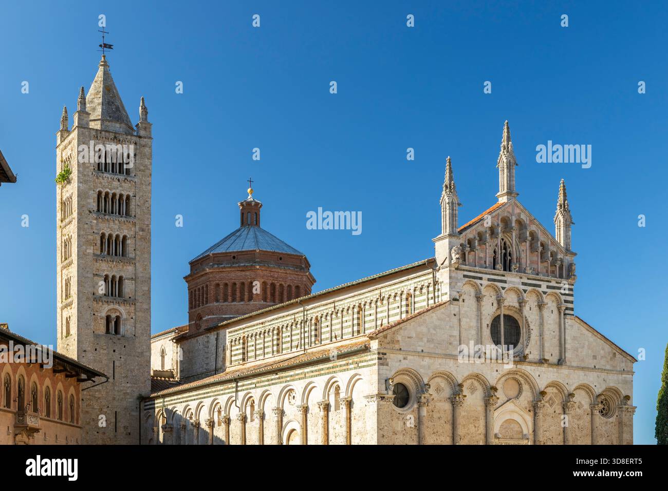 Romanesque cathedral and bell tower under a clear blue sky in Massa ...