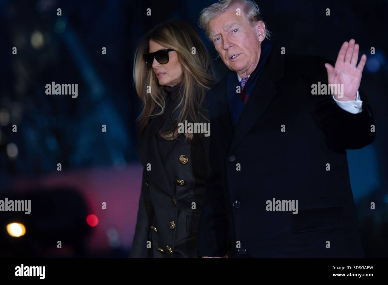 President Donald Trump waves to the media as he holds hands with first ...