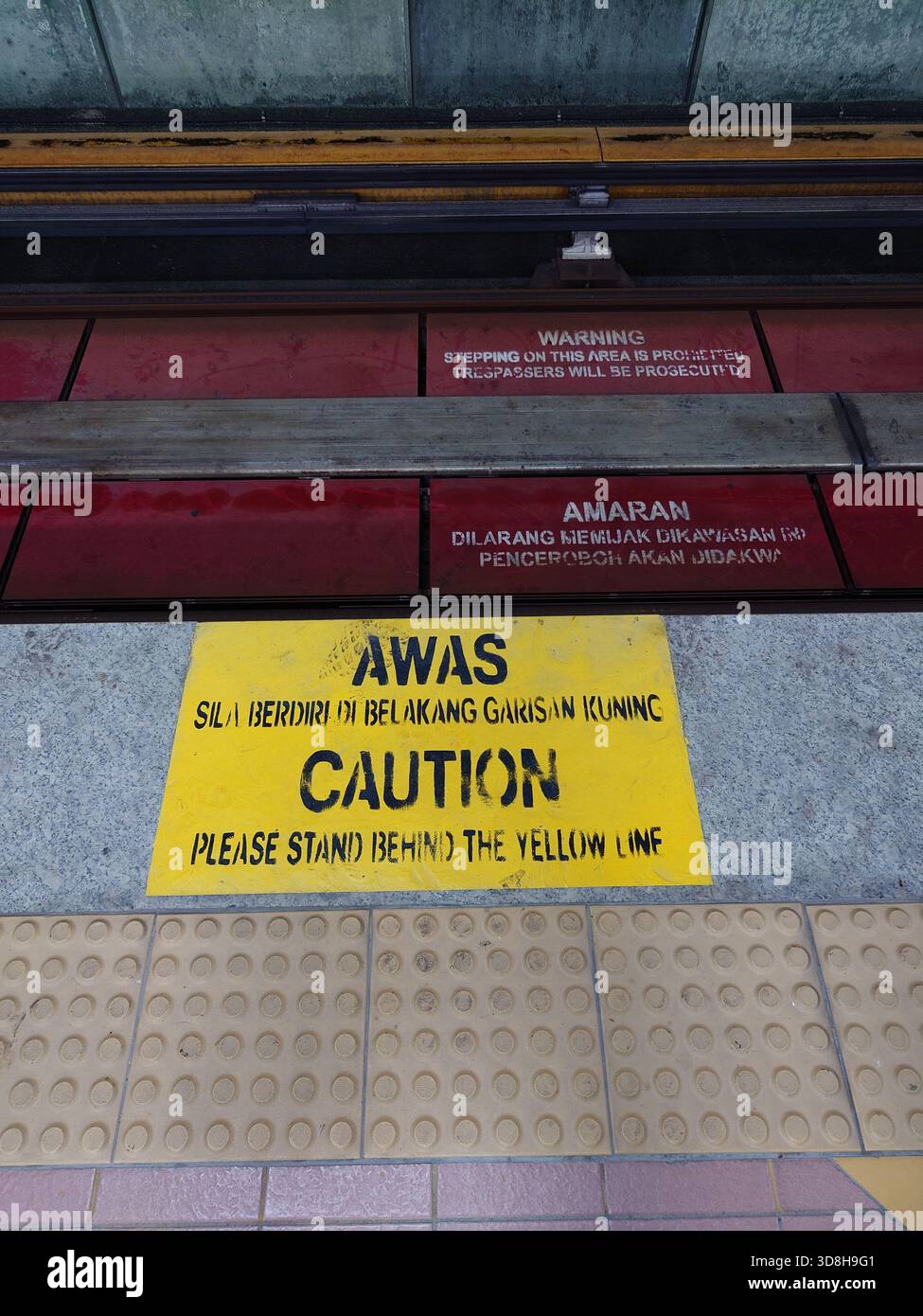 A close-up view of safety warning signs on a train station platform in ...