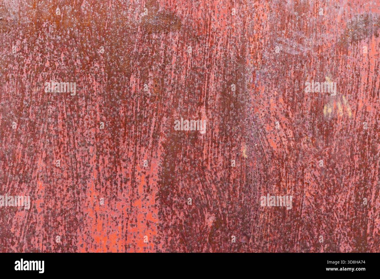 Worn red painted surface with scratches and discoloration, showing ...