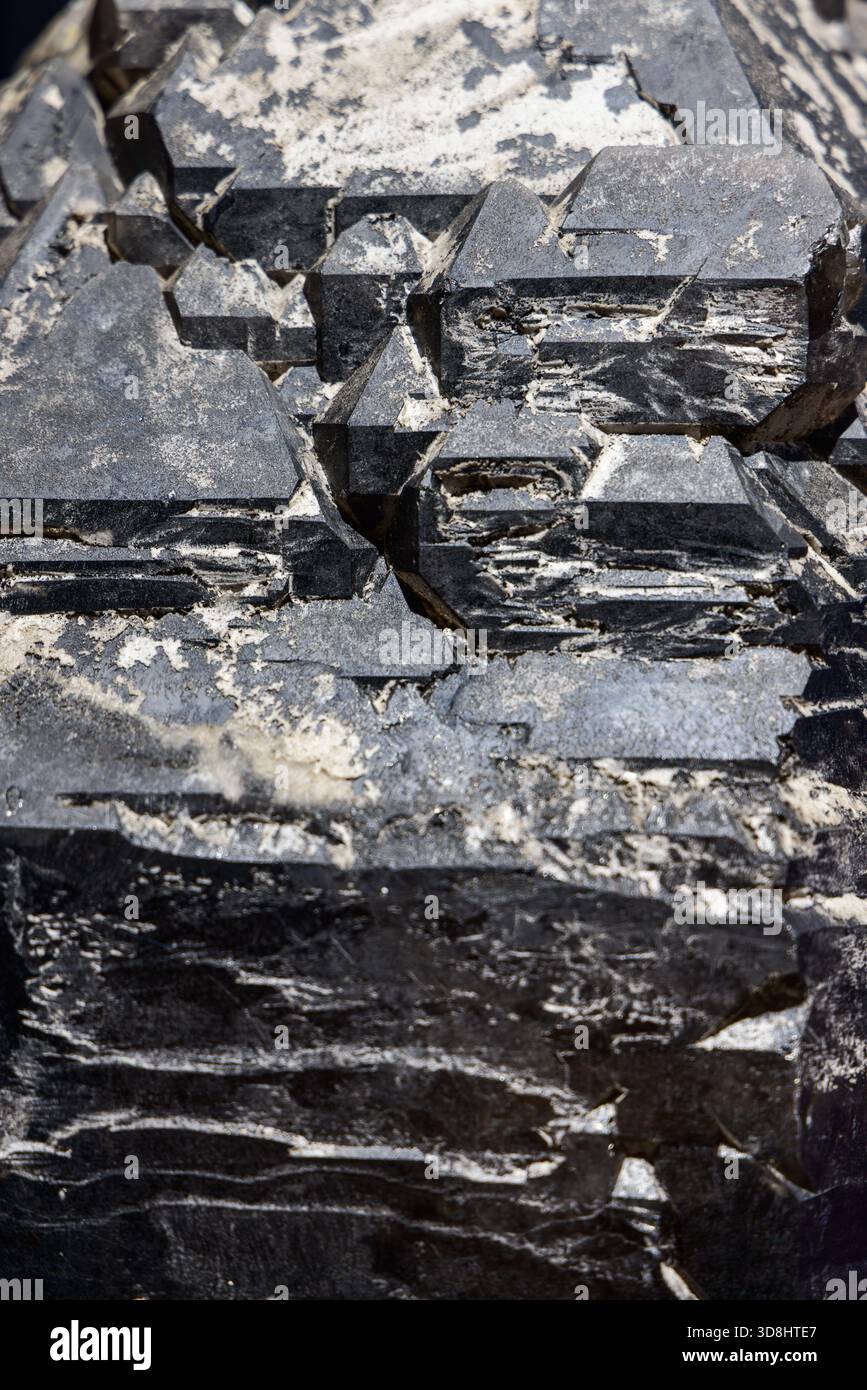 Black tourmaline crystal closeup, prismatic mineral structure with ...