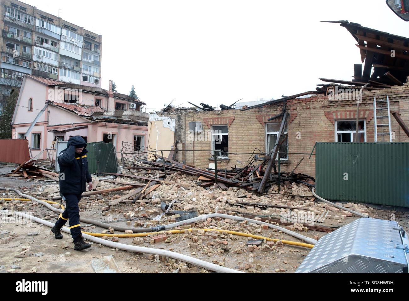 A rescuer walks past the ruins of a private house destroyed in a ...