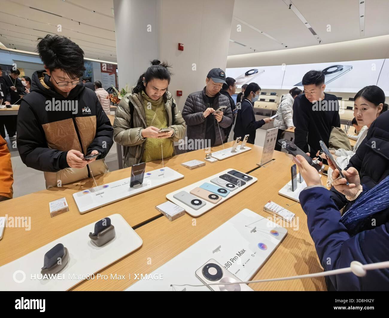 People experience Huawei Mate 80 series phones at a store in Beijing ...