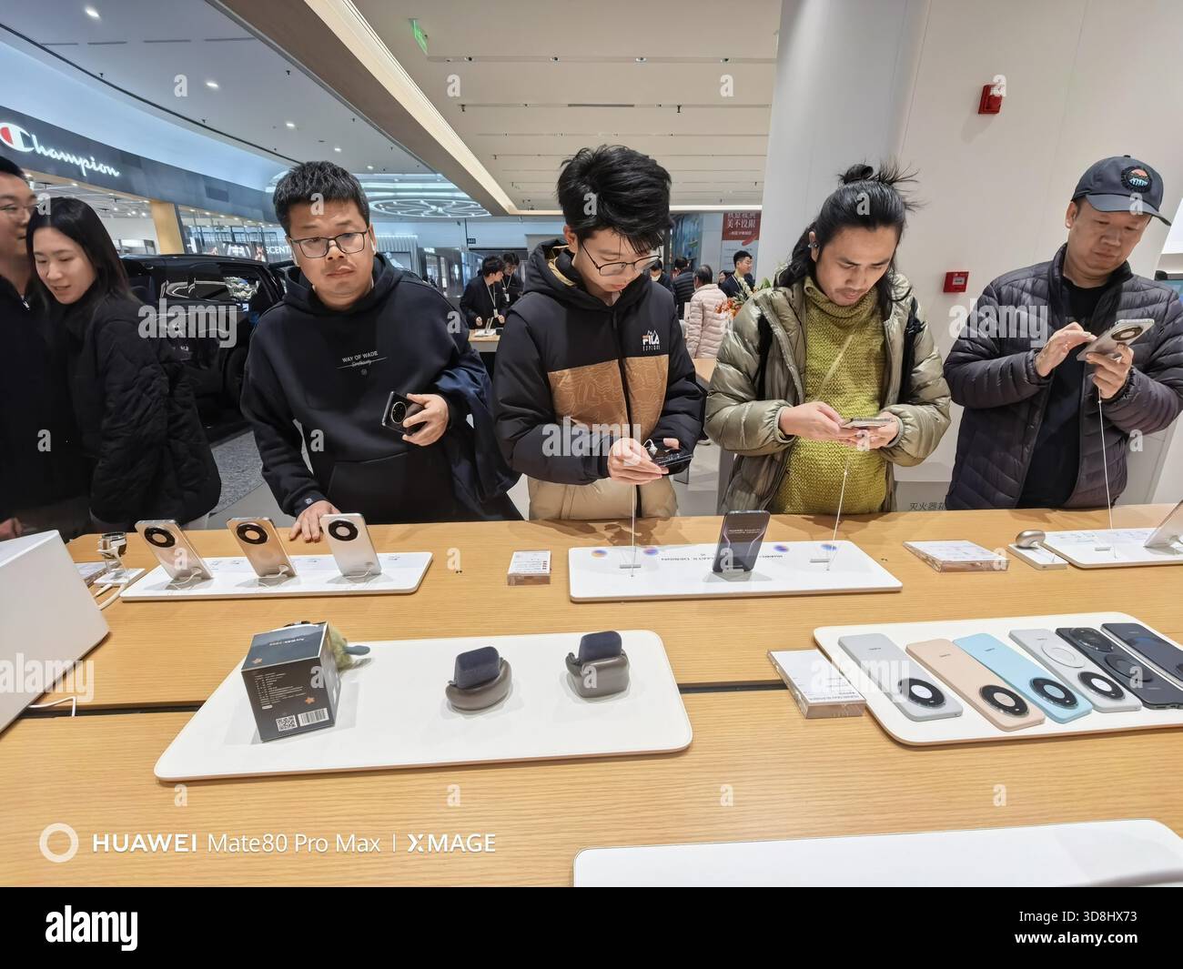 People experience Huawei Mate 80 series phones at a store in Beijing ...