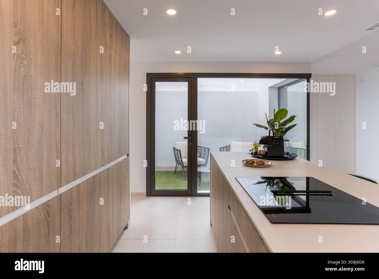 Sleek kitchen with wooden cabinetry, built-in cook top, and access to ...