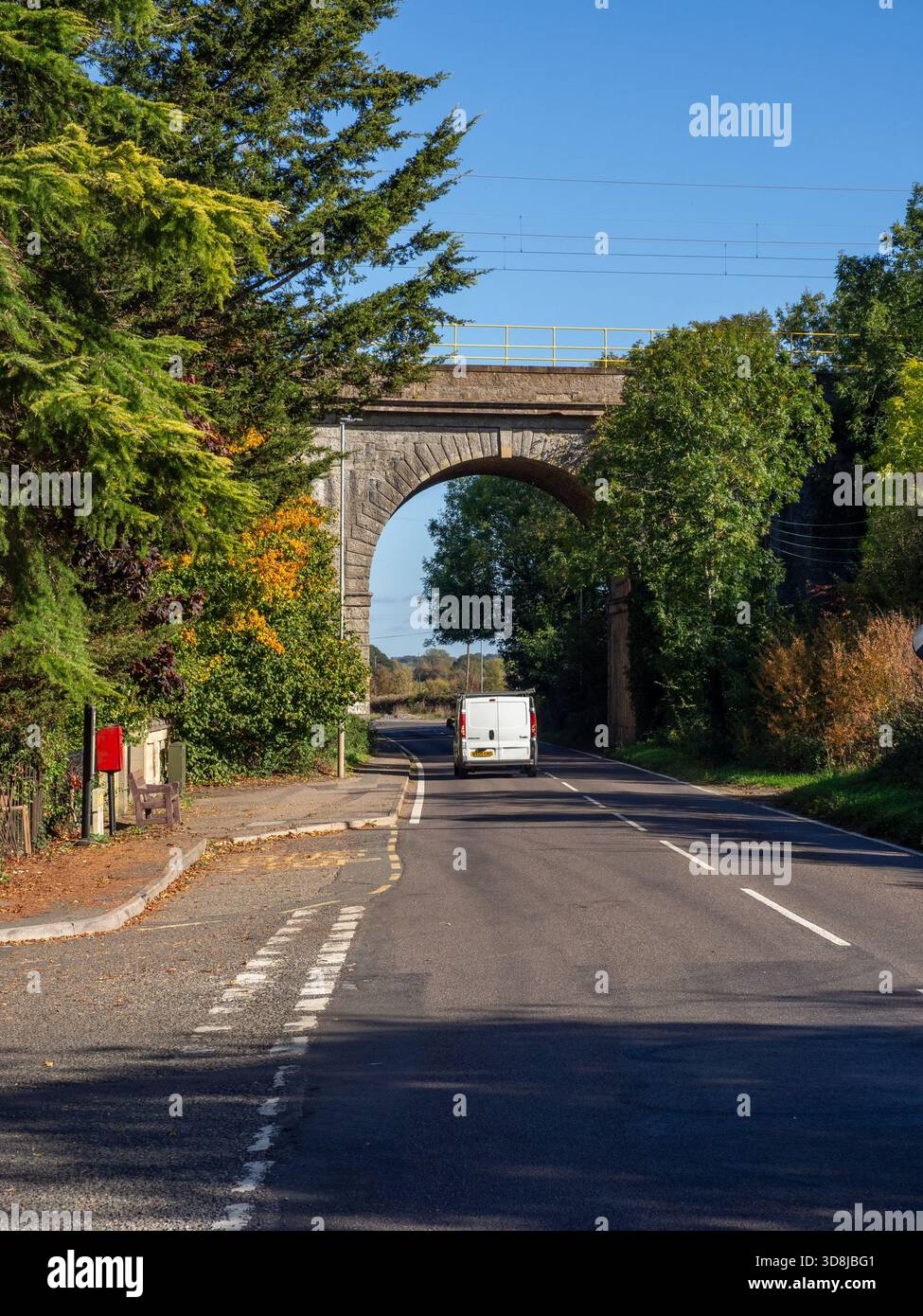 High arched brick railway bridge spanning a quiet road in Blisworth ...