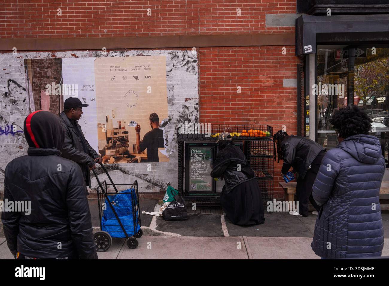 People wait to take food as Kashish Ali and Elliott McKnight stock a ...