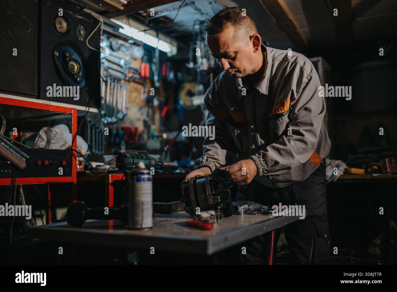 A mechanic works in a cluttered workshop, repairing a machine with ...