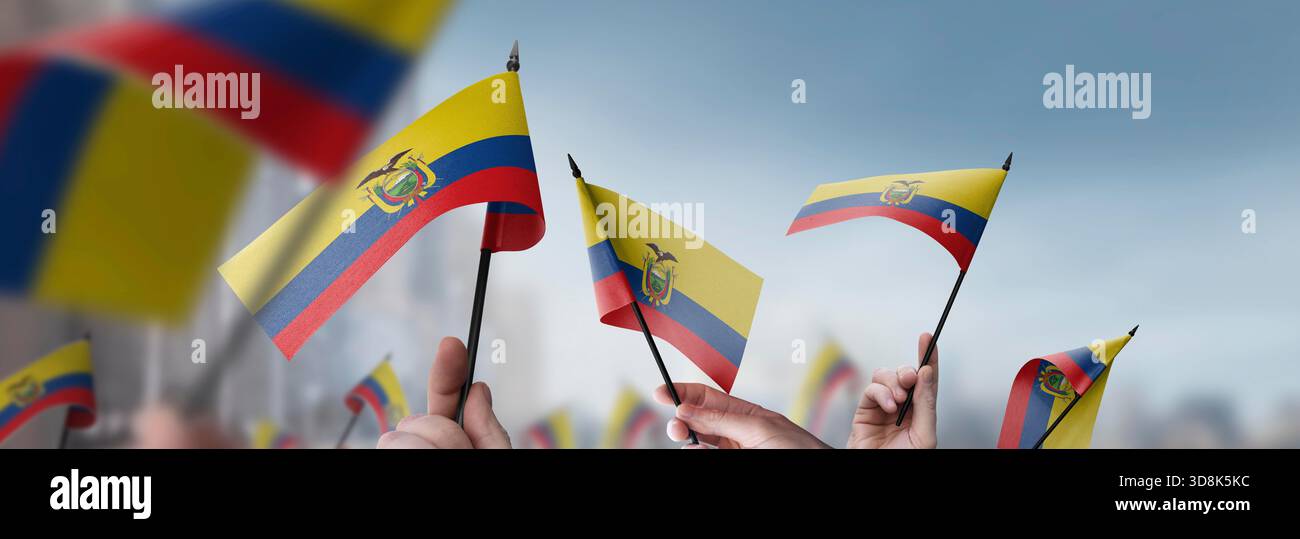 Ecuador flags in their hands on a blurred urban background. The photo ...