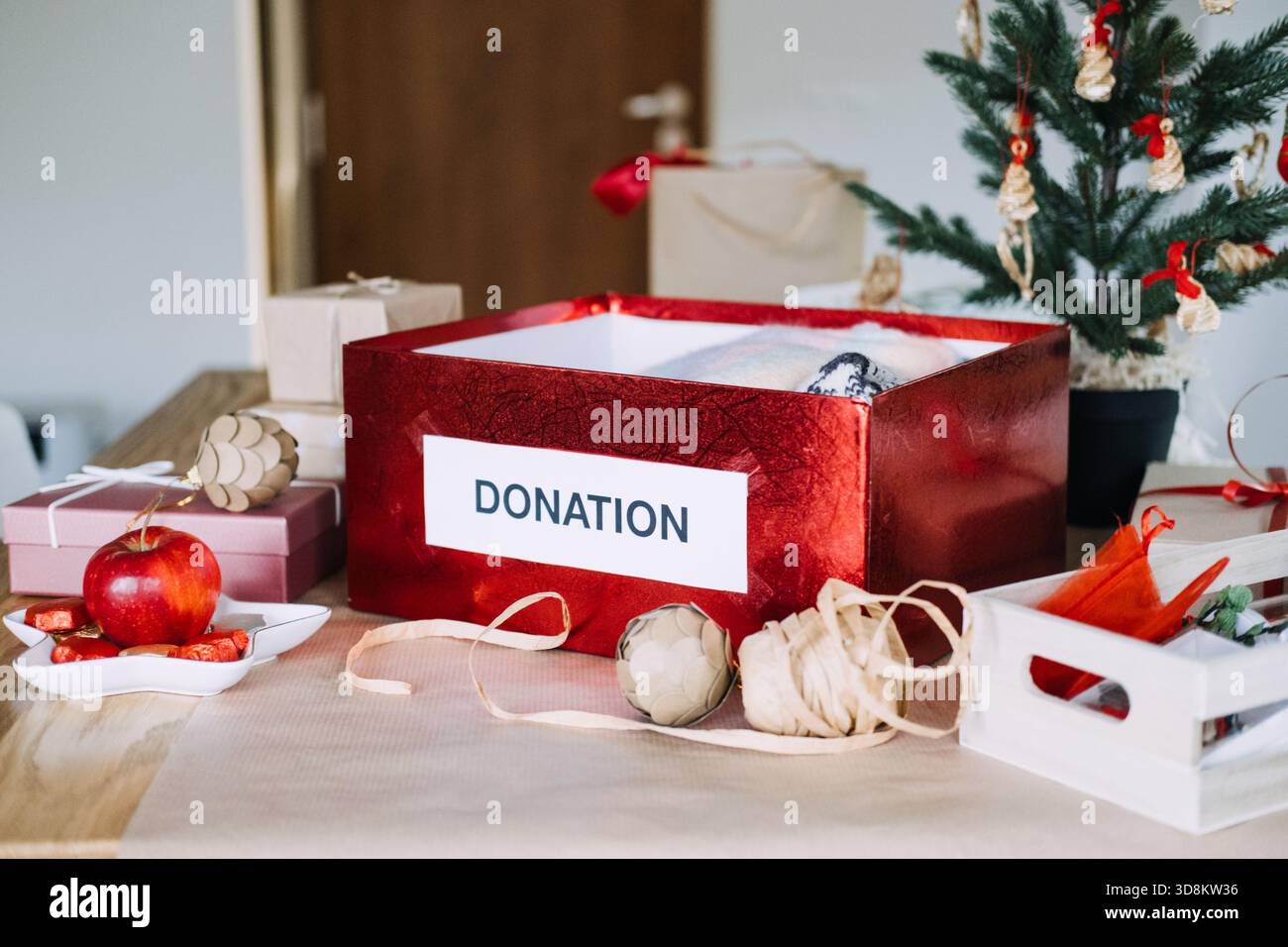 Open red box labeled DONATION sits on table surrounded by wrapped gifts ...