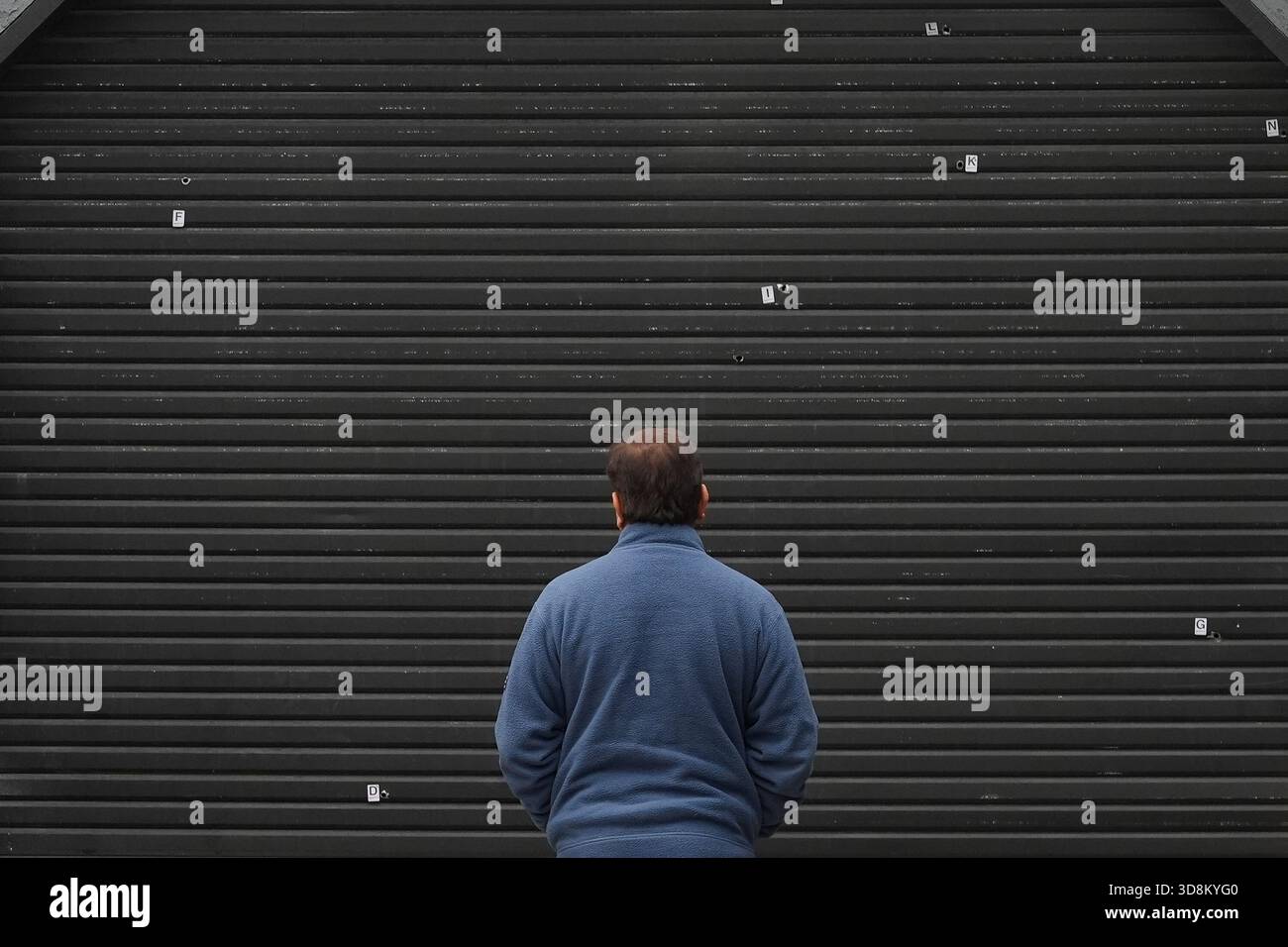 A man looks toward bullet holes where a mass shooting took place ...