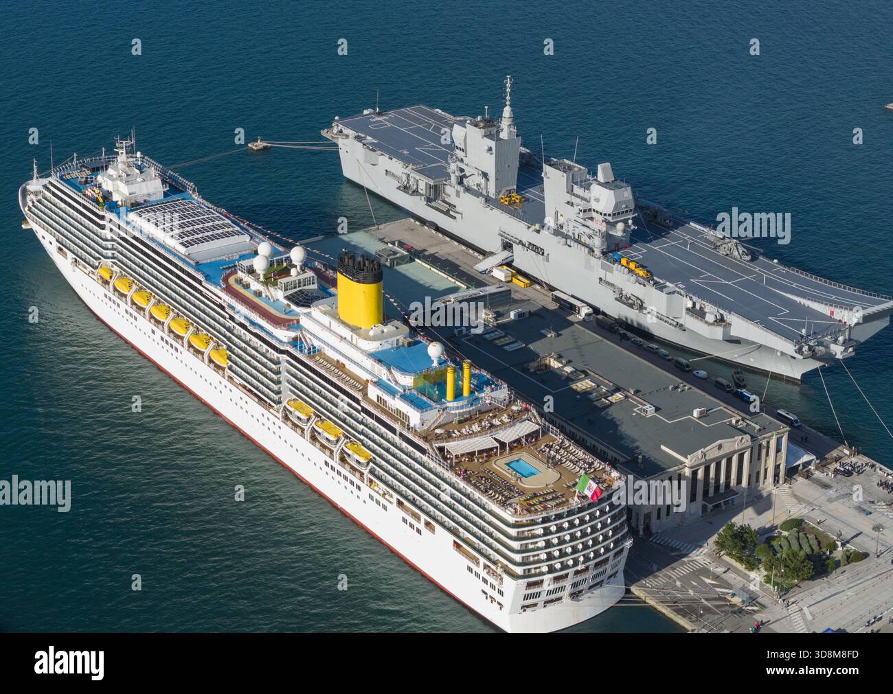 Aerial view of a cruise ship and a navy vessel docked side by side ...