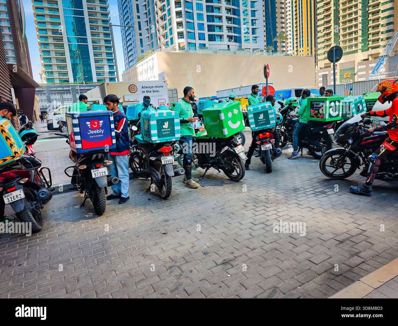 12 01 2025 - Dubai, UAE. Group of Couriers with Scooters Delivering ...