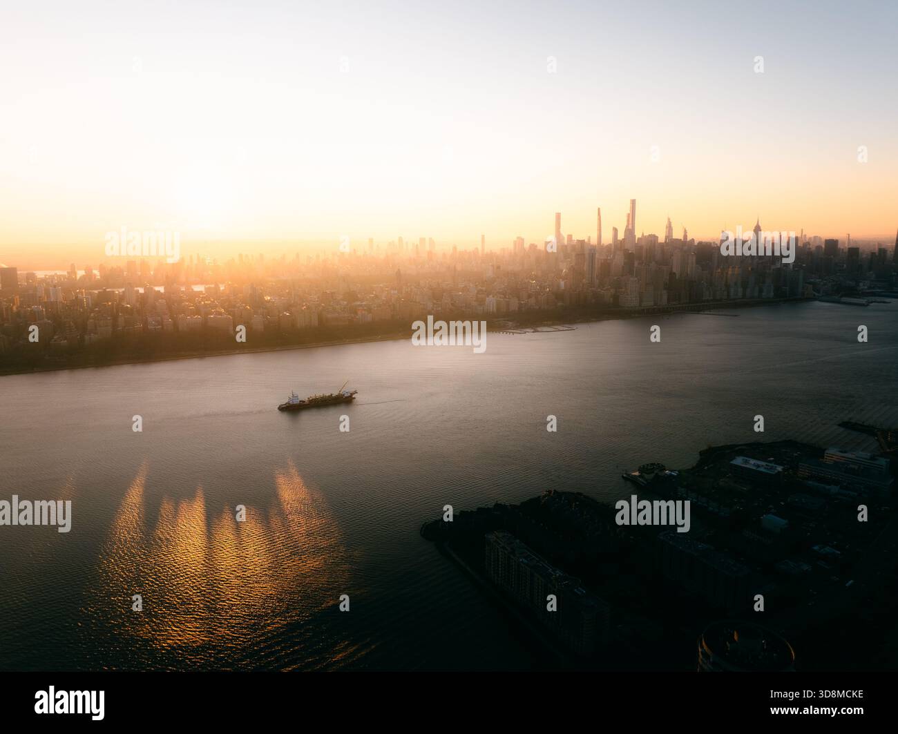 Aerial view of a lone barge sailing the Hudson River, reflecting the ...