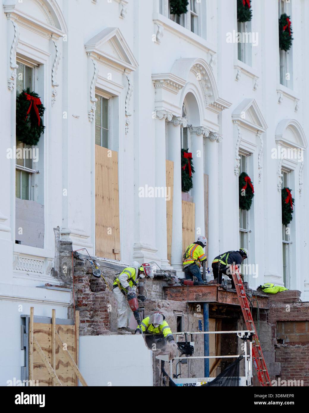 A worker throws bricks as construction of a new ballroom continues on ...