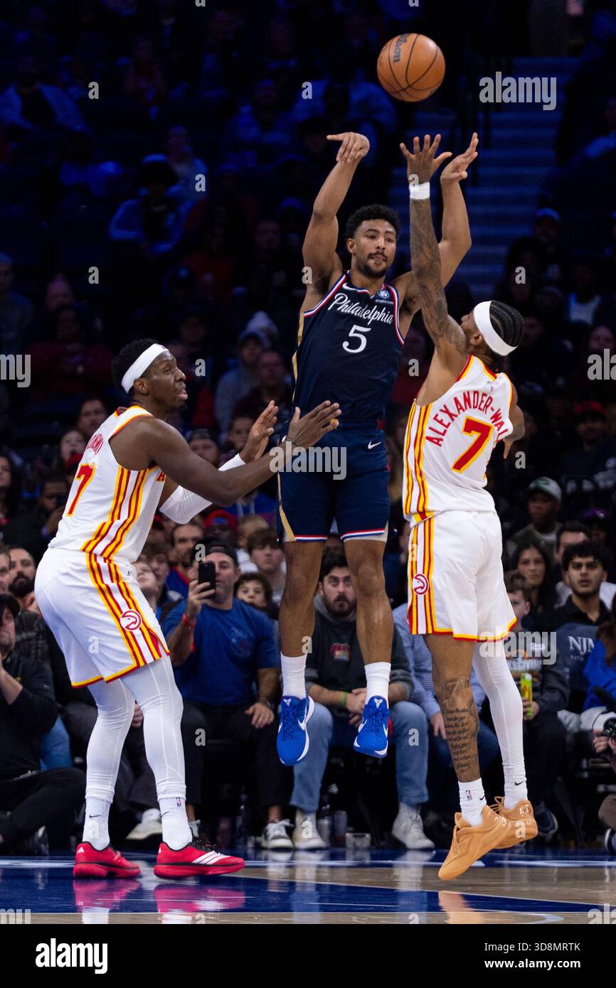 Philadelphia 76ers' Quentin Grimes, center, passes the ball while guarded by Atlanta Hawks ...