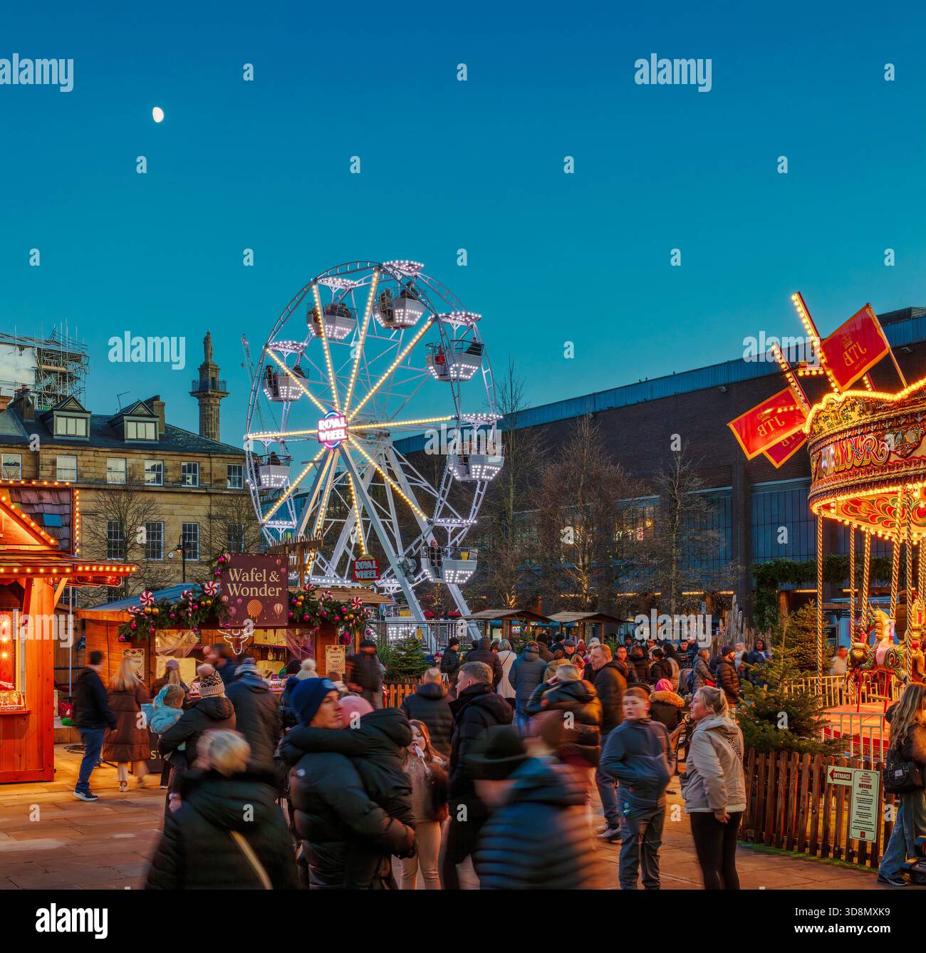 A view at dusk at christmas of the christmas market and festive rides ...