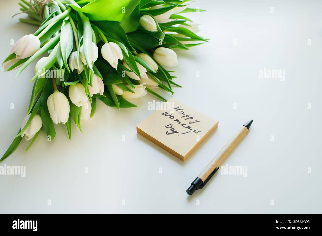 Sticky note with Women's day handwritten congratulations and white ...