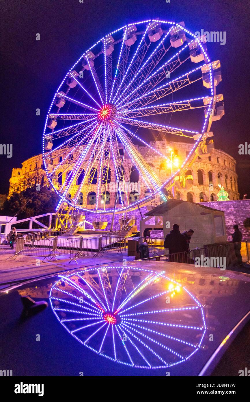 Ferris wheel is seen near the Roman amphitheater in Pula, Croatia, on ...
