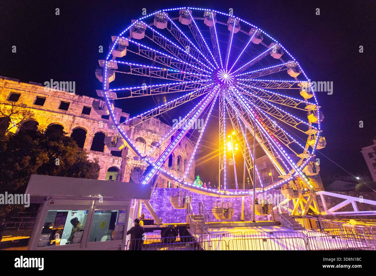 Ferris wheel is seen near the Roman amphitheater in Pula, Croatia, on ...
