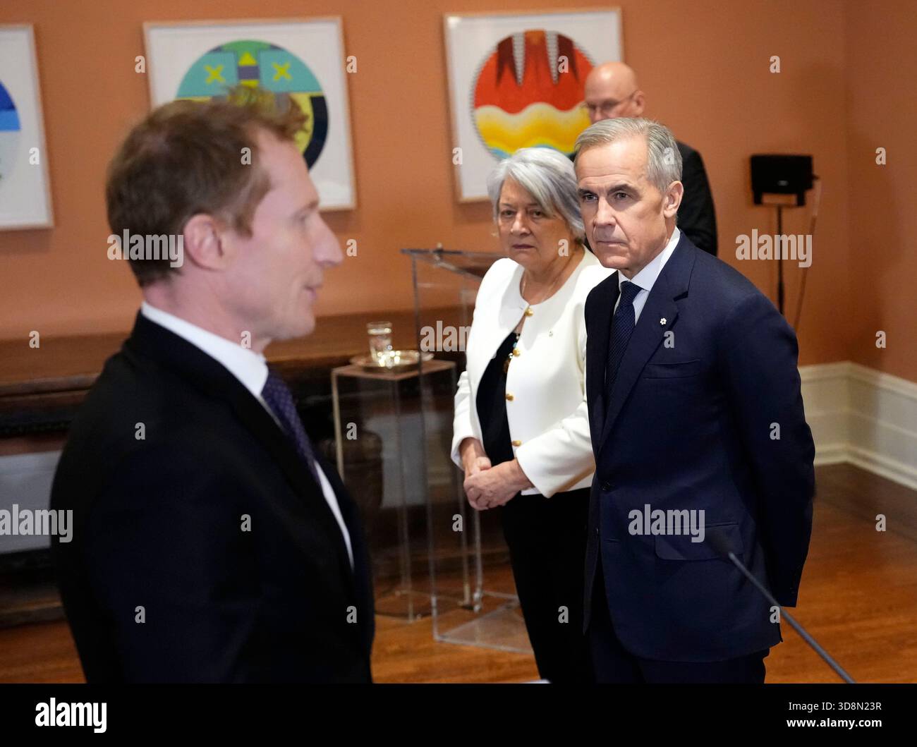 Prime Minister Mark Carney looks on as Mark Miller is sworn in as ...