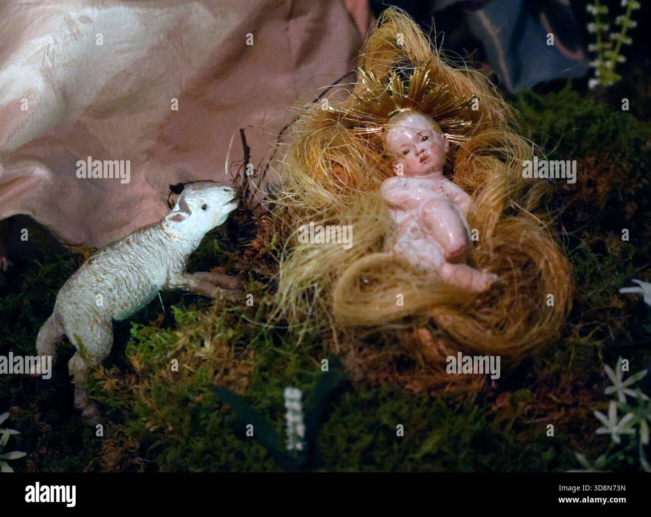 A infant Jesus figurine is on display under a Christmas Tree and ...