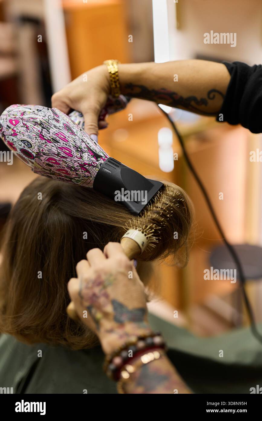 Hair educator demonstrating volumizing blowout technique Stock Photo ...
