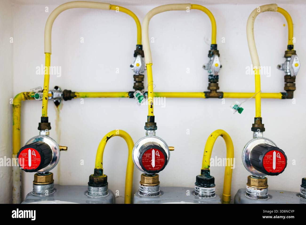 Industrial gas meters with yellow piping and valves, highlighting the ...