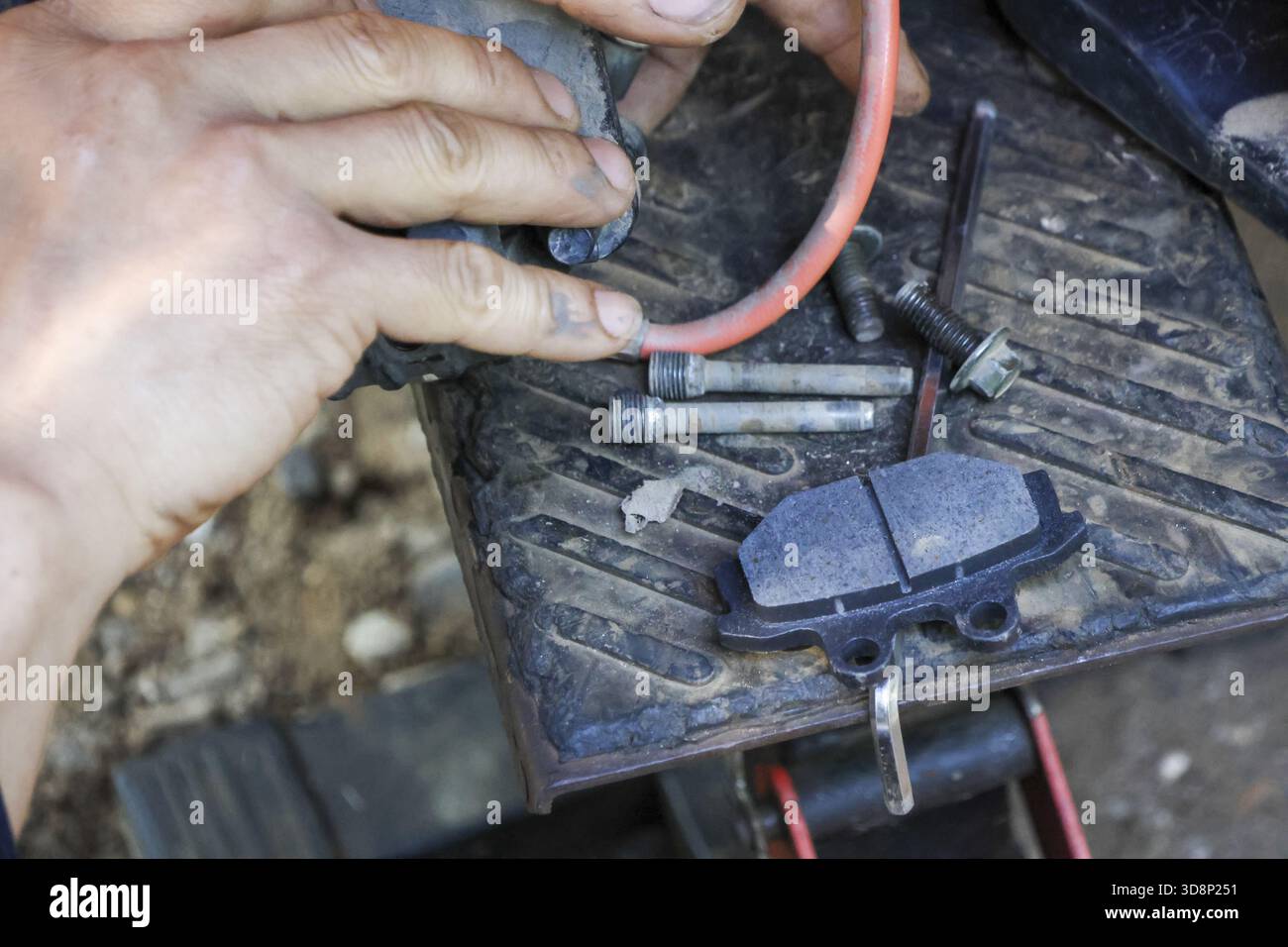 Focused mechanic hand performing repair on automotive vehicle brake ...