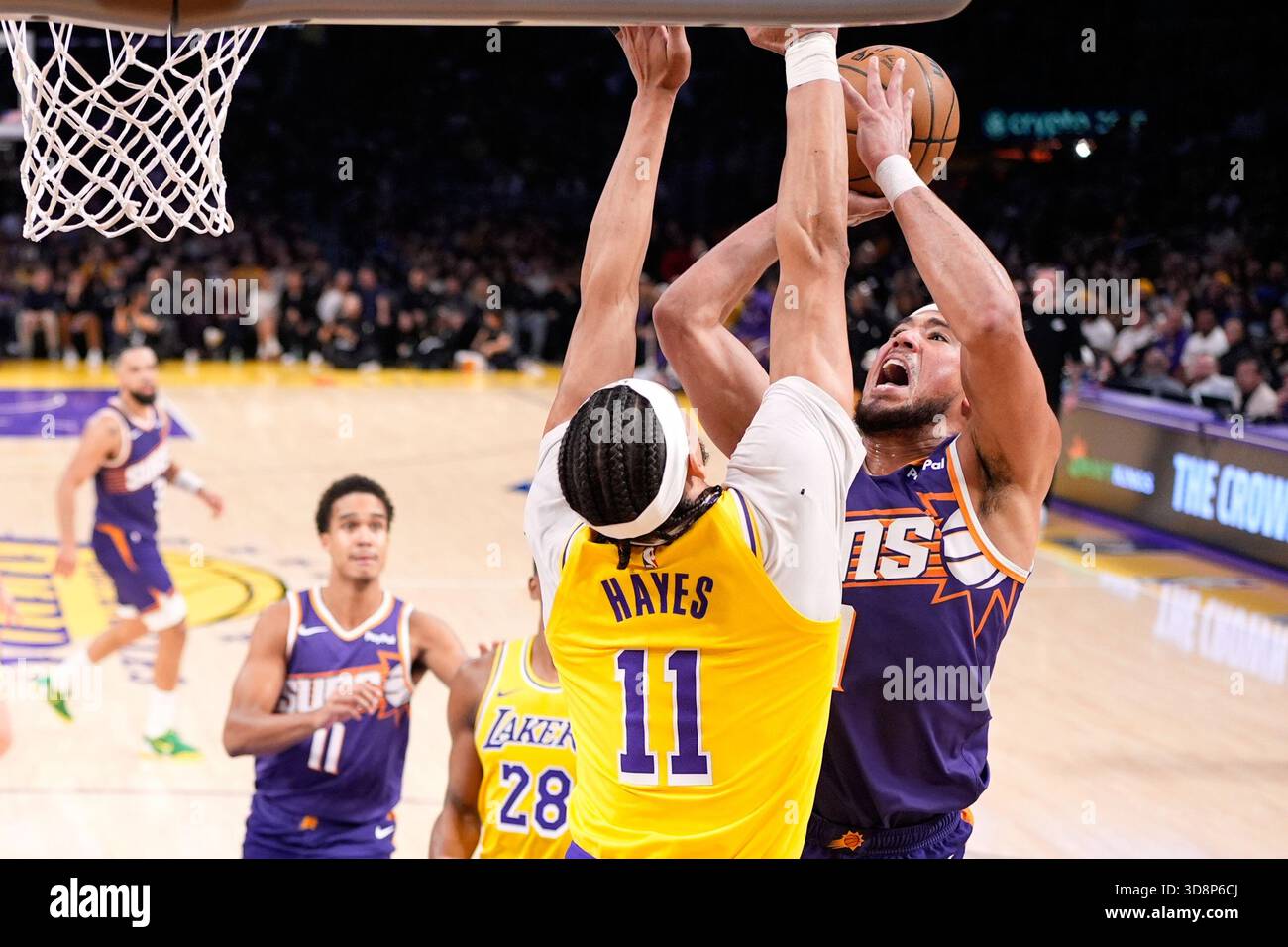 Phoenix Suns guard Devin Booker, right, shoots as Los Angeles Lakers ...