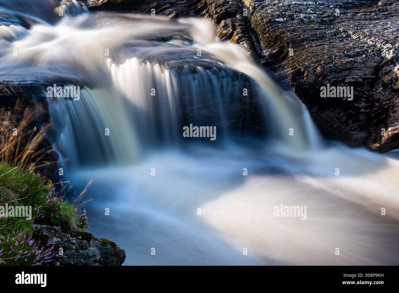 Flowing water over rock captured with long exposure to create smooth ...
