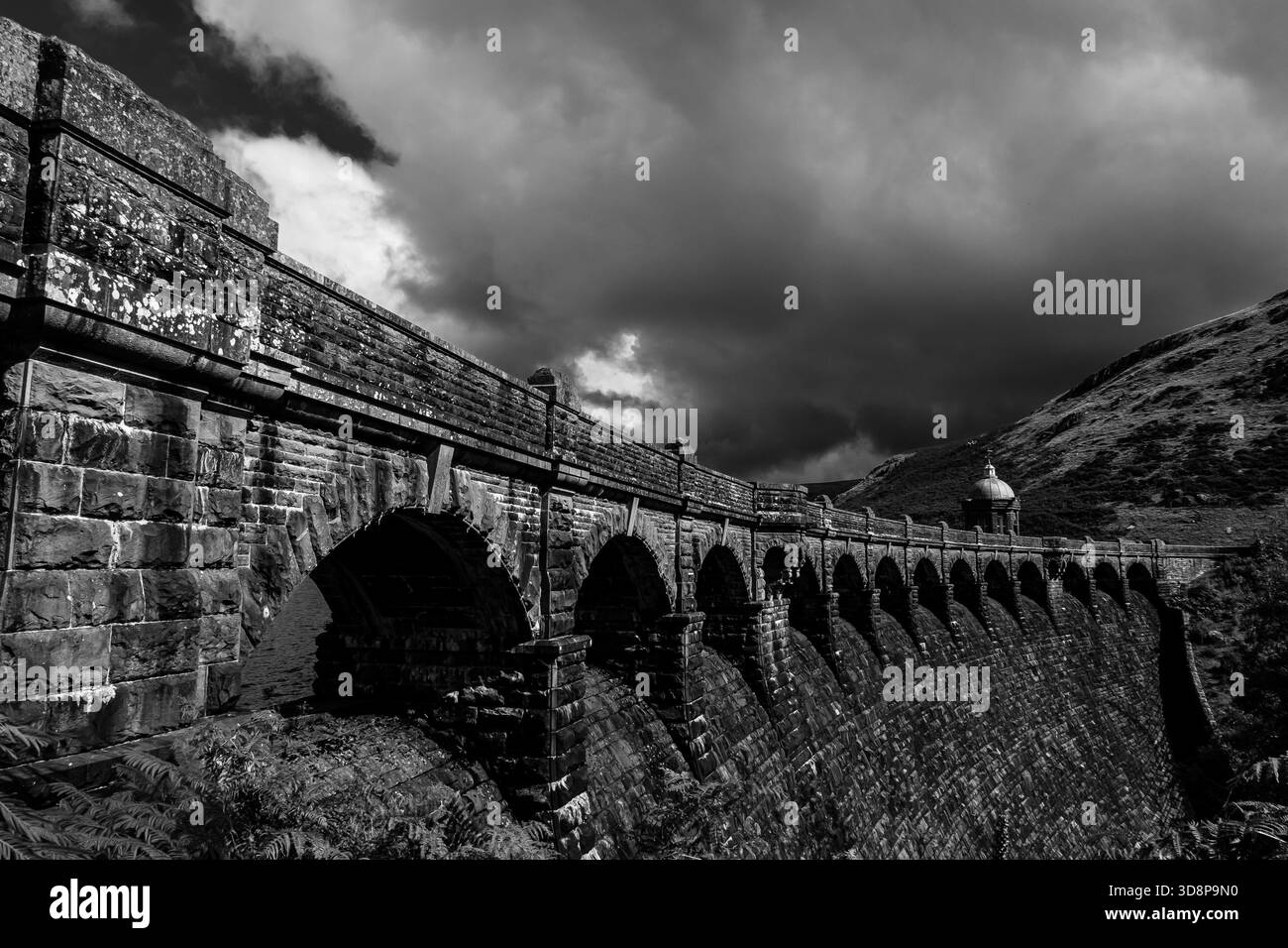 Black and white view of Craig Goch Dam with dramatic clouds above and ...