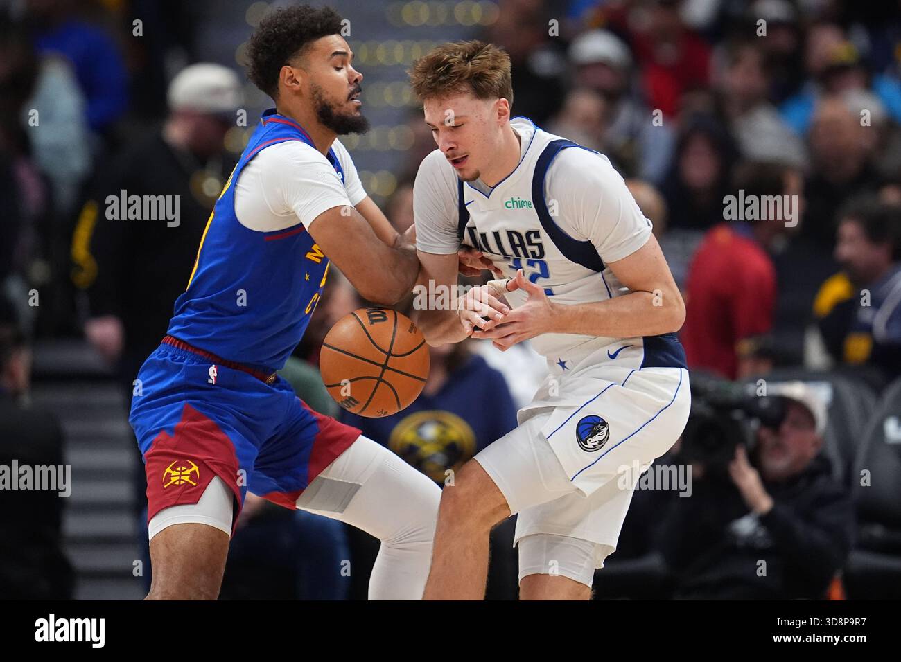 Denver Nuggets forward Cameron Johnson, left, knocks the ball out of ...