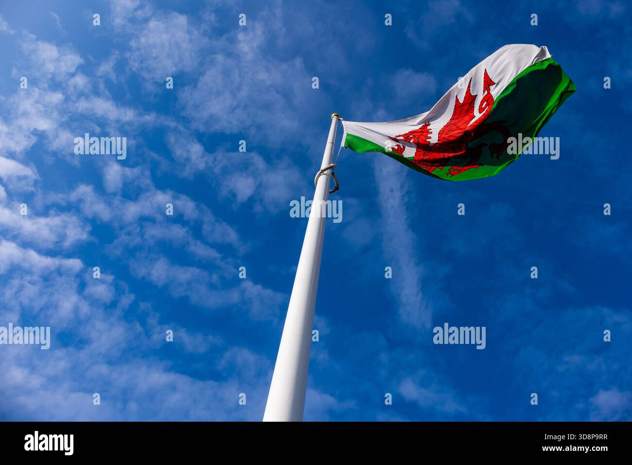 Welsh flag flying against a blue sky Stock Photo - Alamy