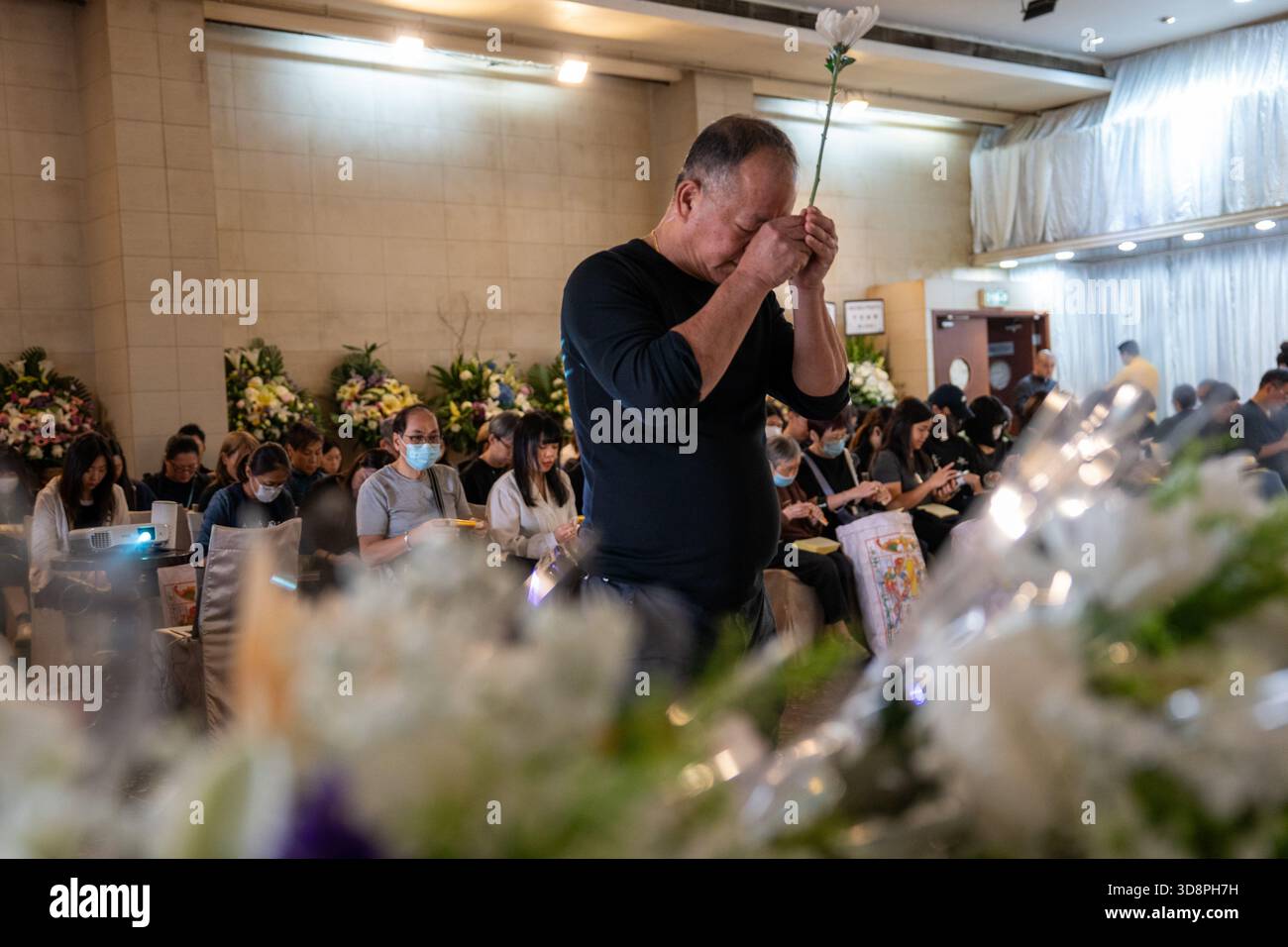A mourner at a memorial in a funeral home for the victims who lost ...