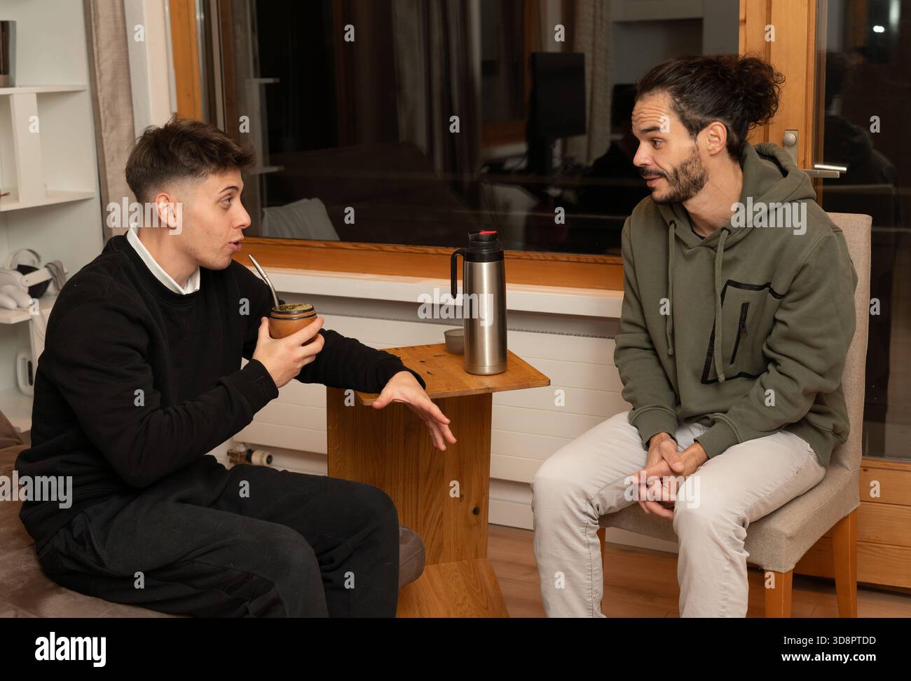 Two friends indoors sharing mate tea while talking and relaxing Stock ...