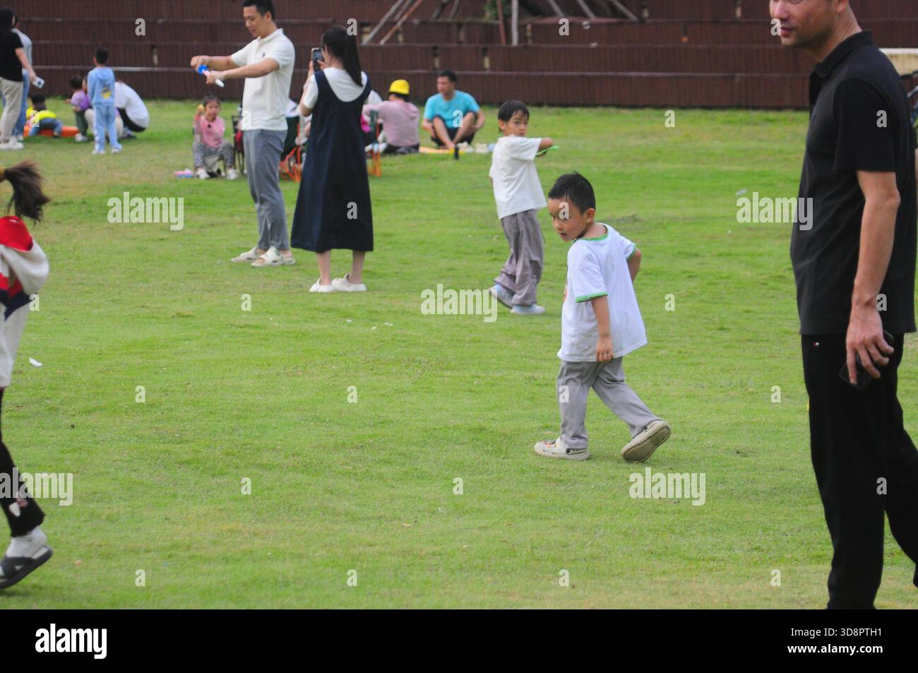 Parents take their children to play at a park in Sanya City ...
