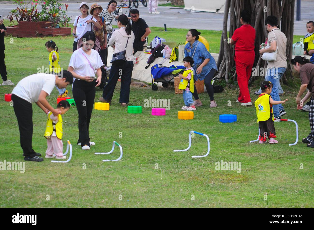 Parents take their children to play at a park in Sanya City ...