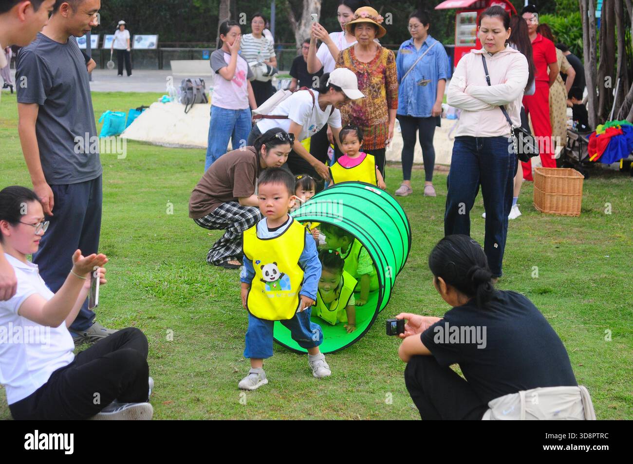 Parents take their children to play at a park in Sanya City ...