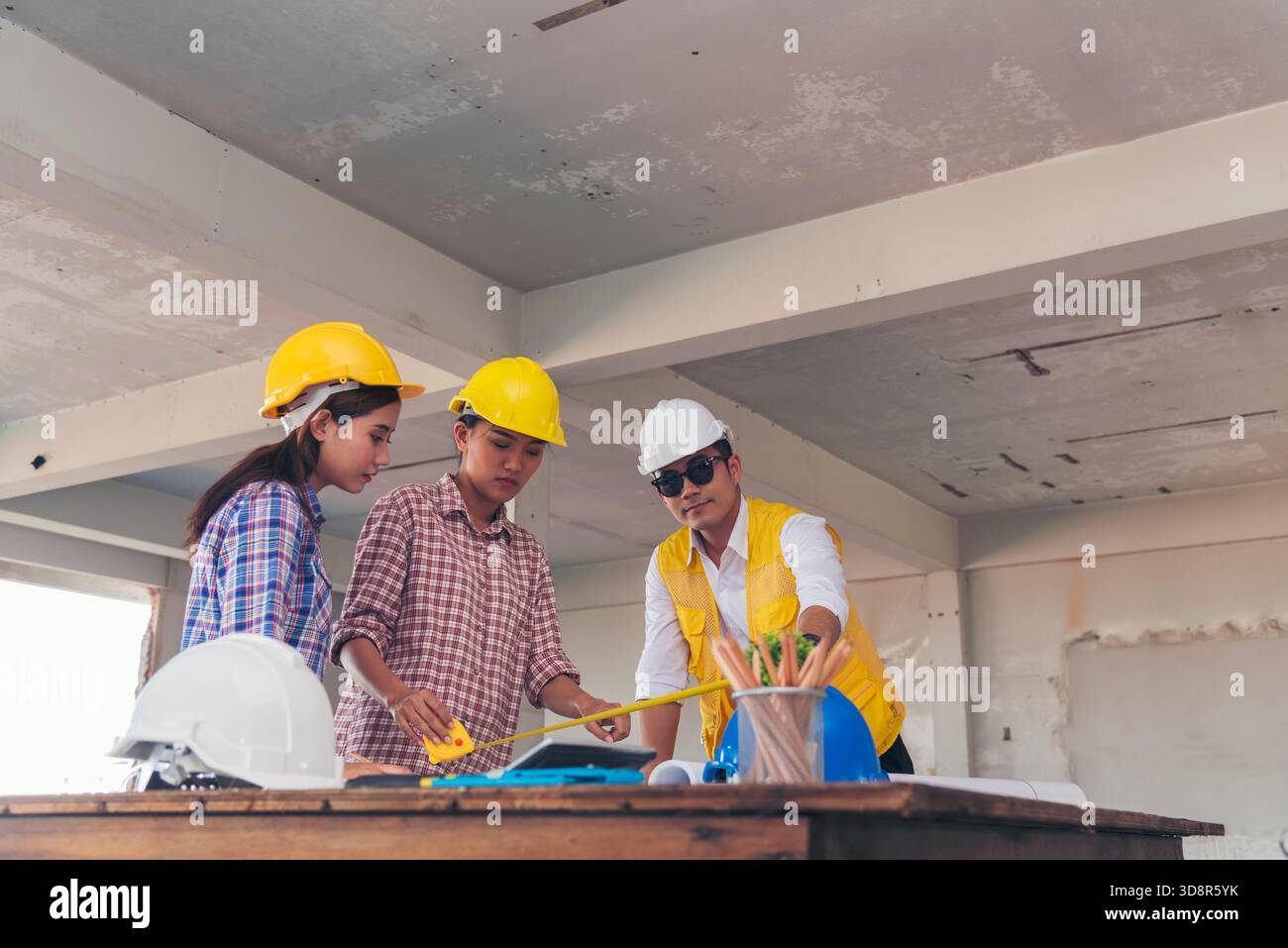 Civil engineer teams meeting working together wear worker helmets hardhat on construction site ...