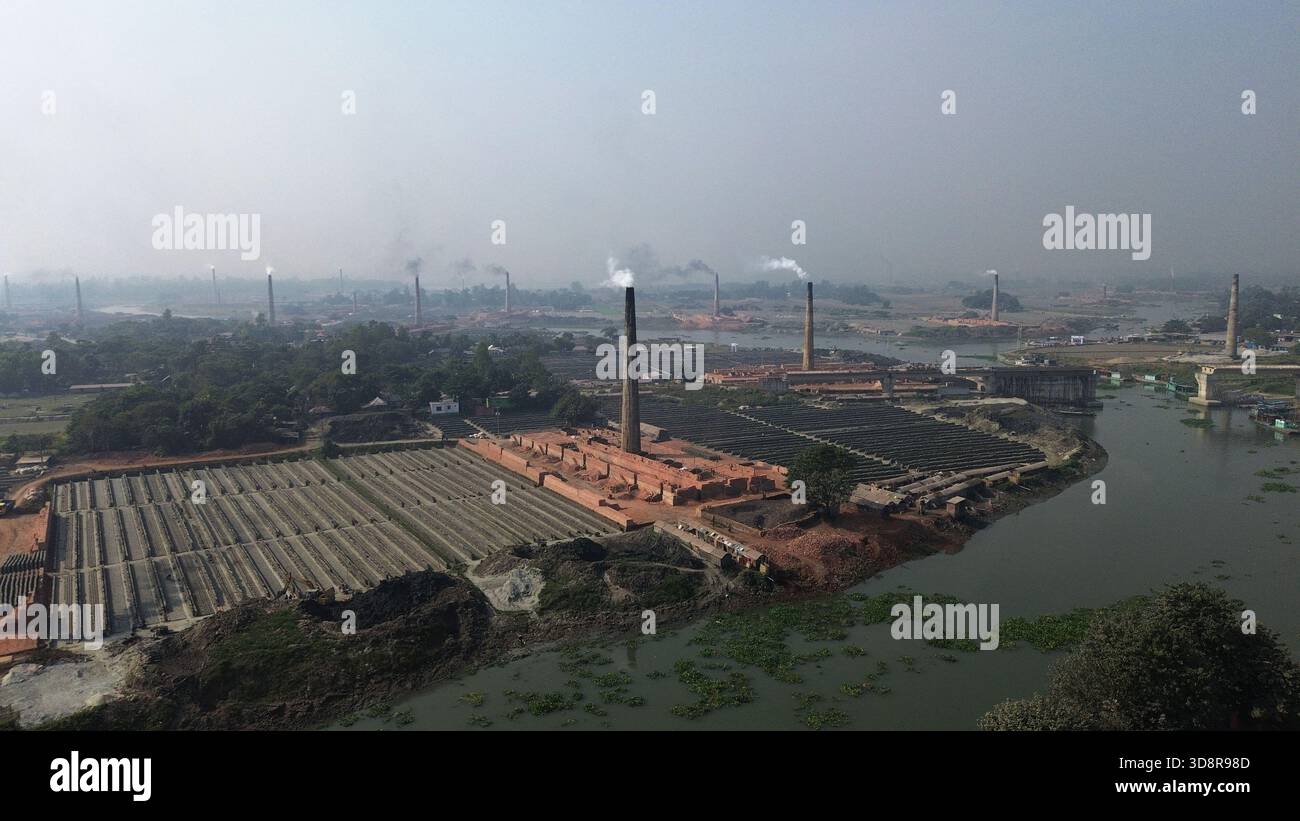 Smoke is emitting from the chimneys at a brick factory on the outskirts ...