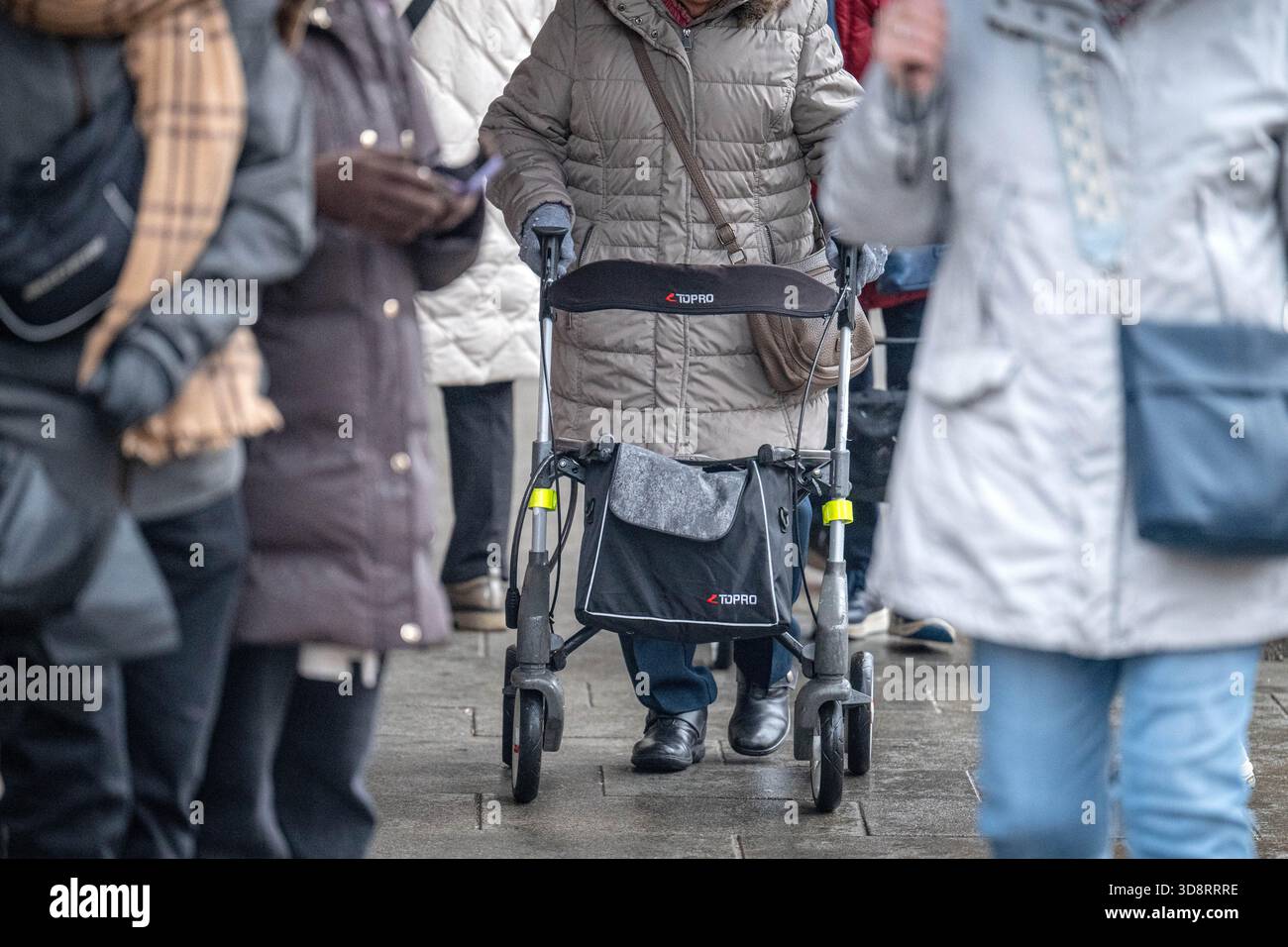 02 December 2025, Bremen: An elderly person with a walking frame walks ...