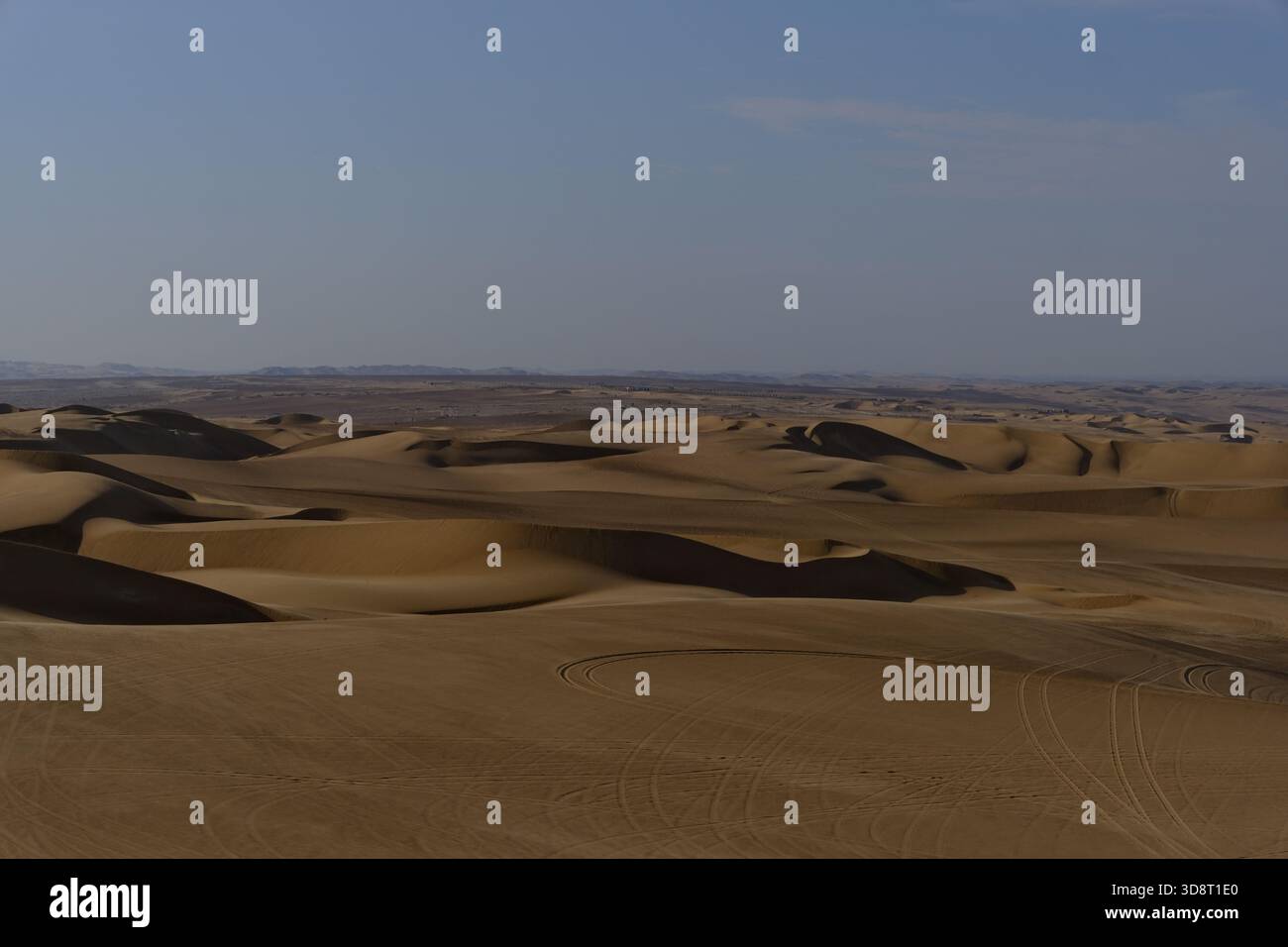 Sweeping sand dunes in the Ica Desert of Peru under a clear blue sky ...