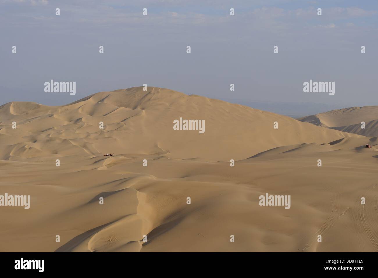 Sweeping sand dunes in the Ica Desert of Peru under a clear blue sky ...