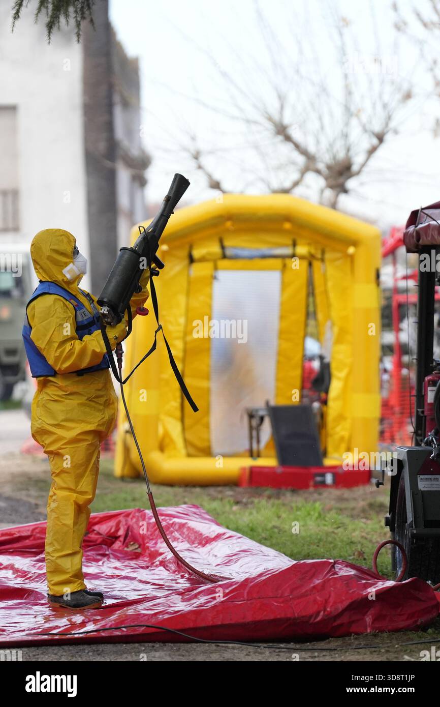 A member of the EMU disinfects vehicles during the presentation of the ...