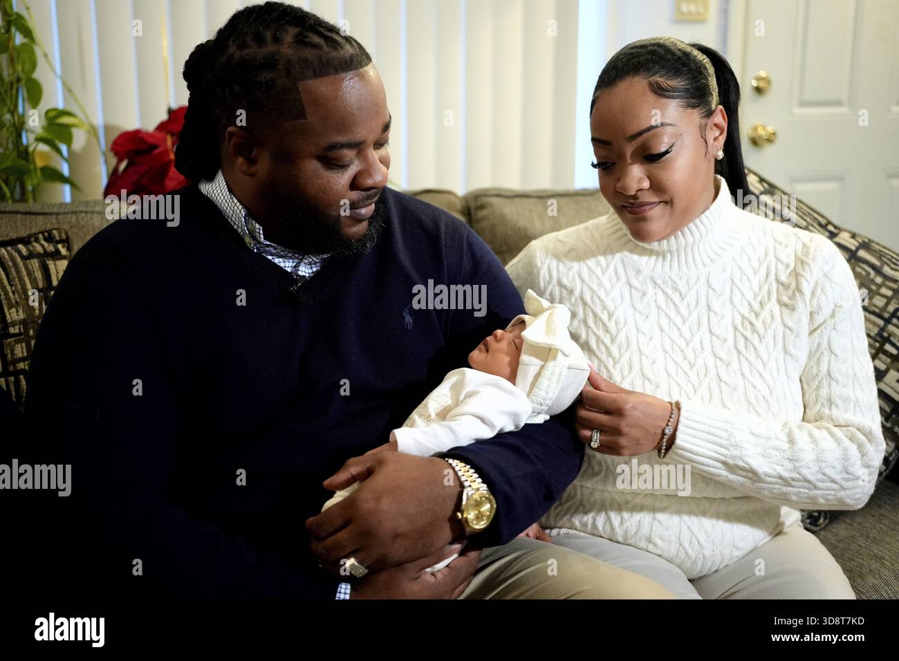 Leon and Mercedes Wells hold their newborn daughter Alena at their home ...