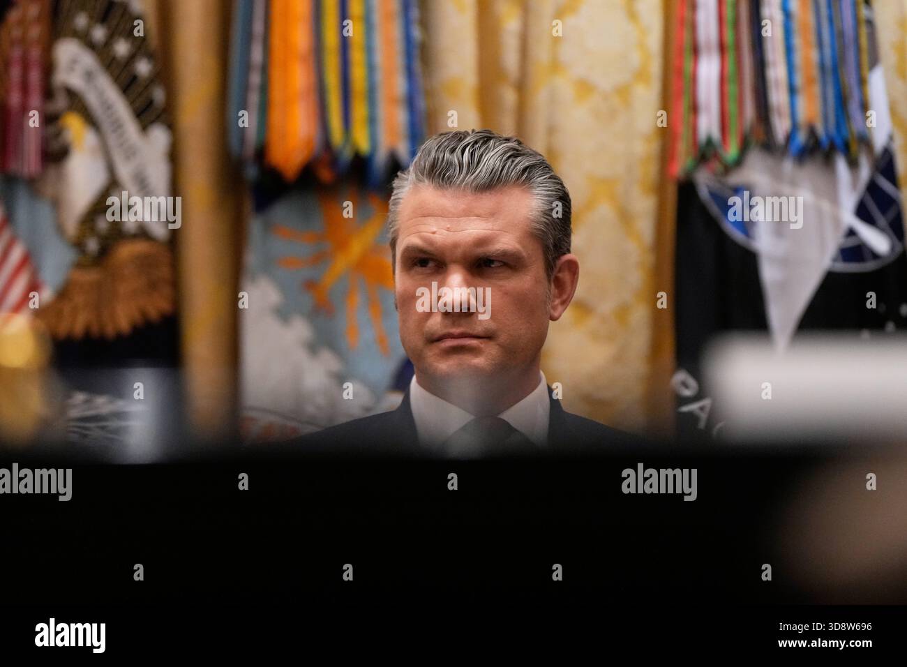 Defense Secretary Pete Hegseth listens as President Donald Trump speaks ...