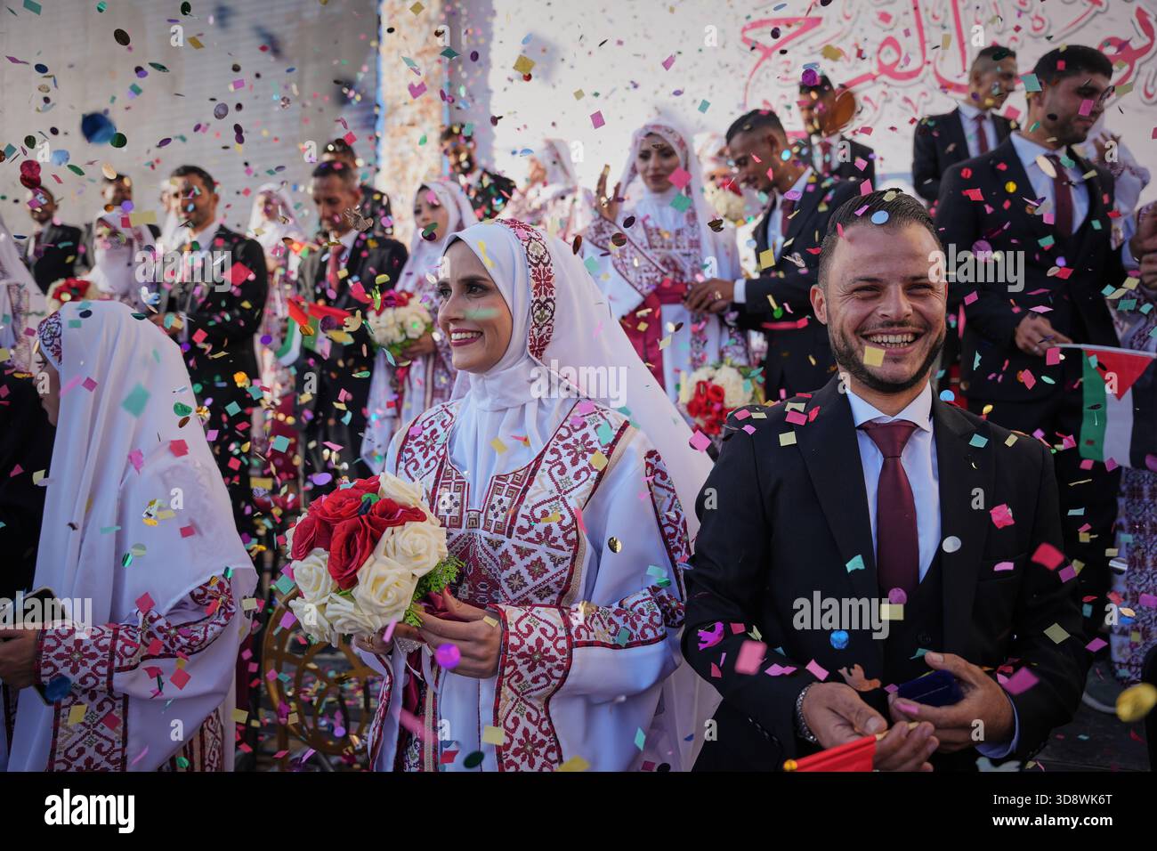 Palestinian couples participate in a mass wedding ceremony in Hamad ...