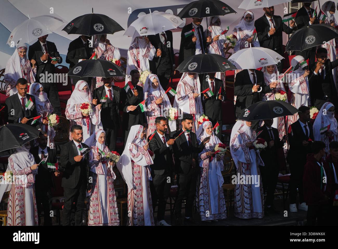 Palestinian couples participate in a mass wedding ceremony in Hamad ...